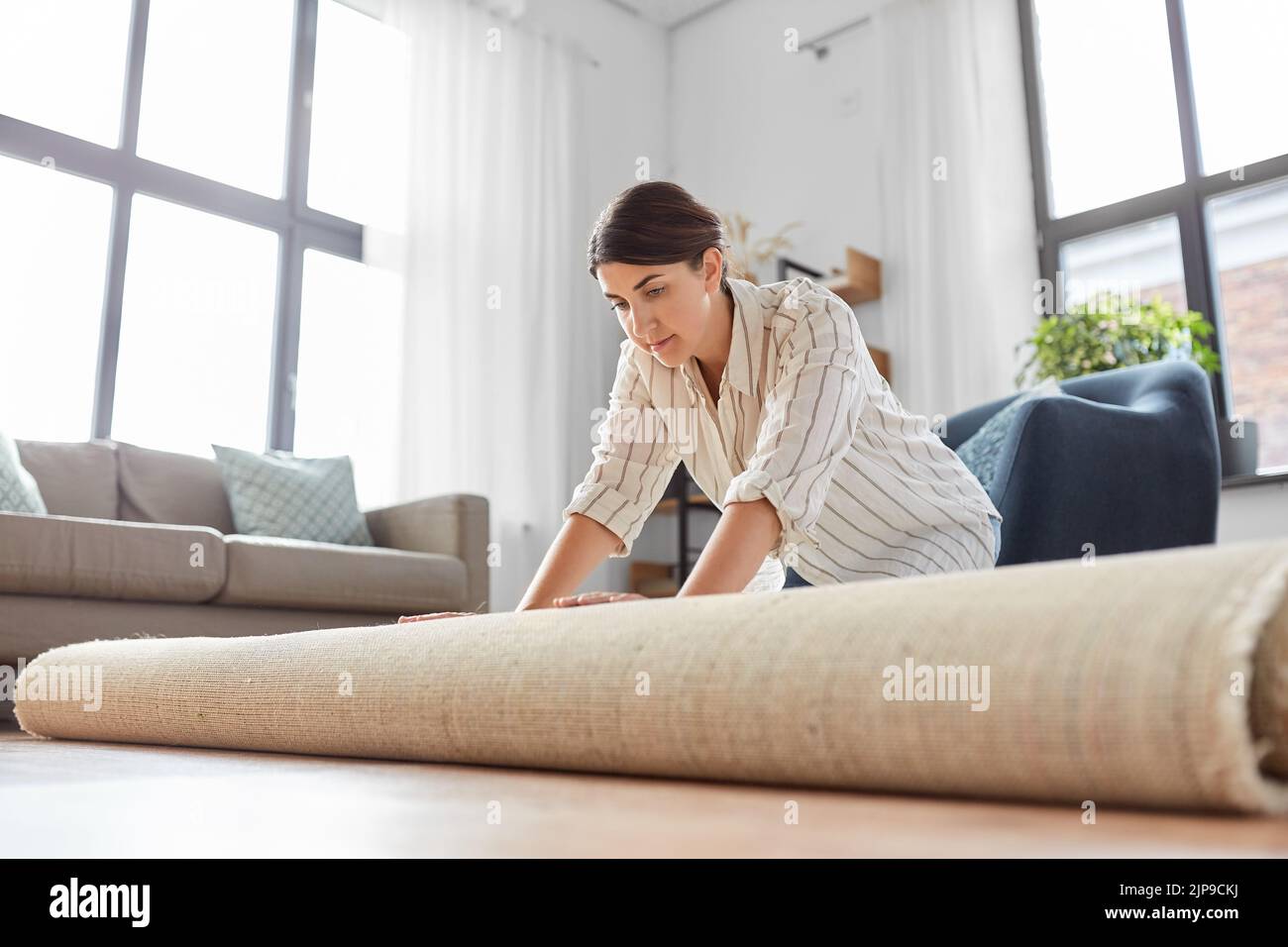 Young woman unfolding carpet hi-res stock photography and images - Alamy