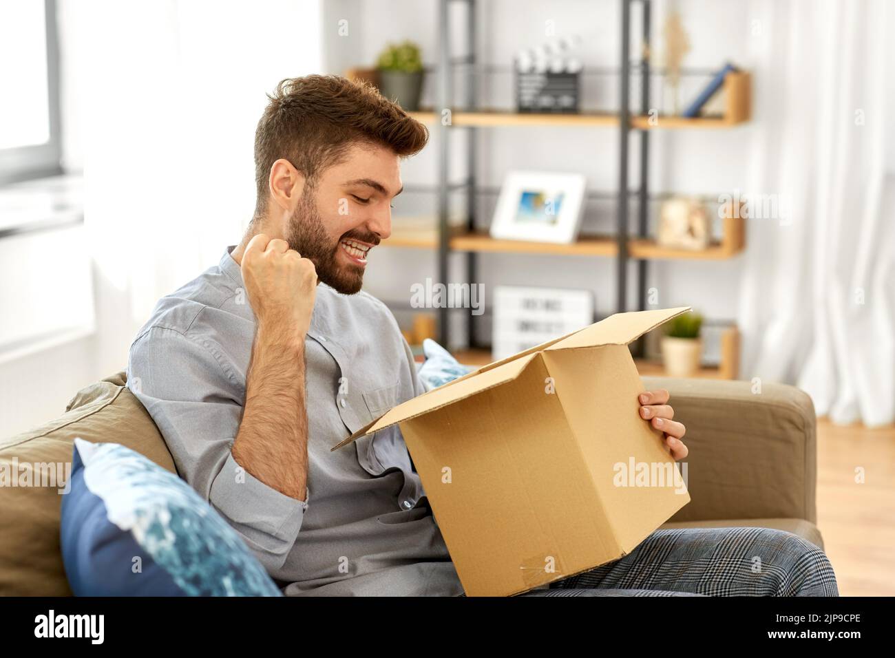happy man opening parcel box at home Stock Photo - Alamy