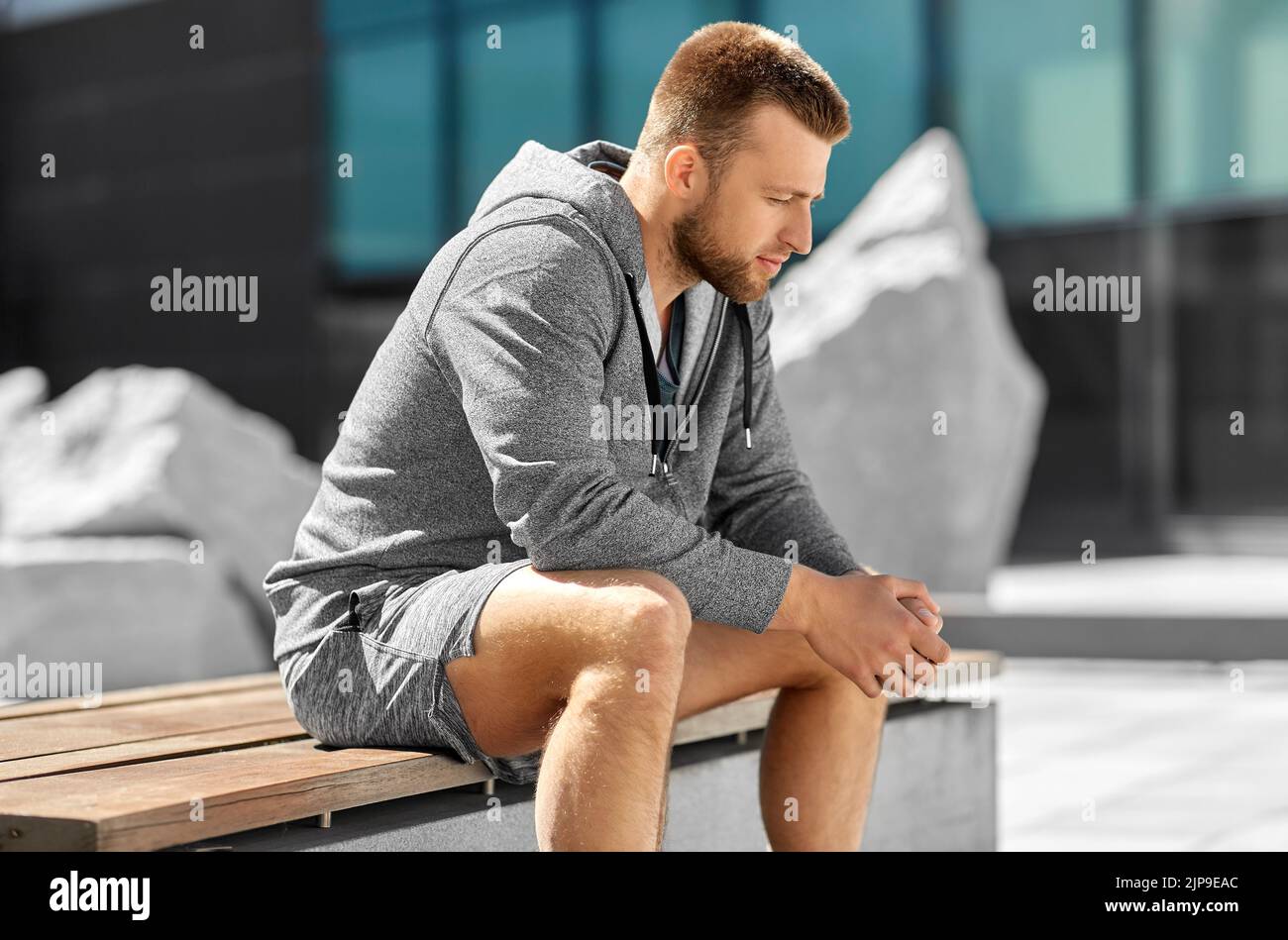 young man sitting on bench outdoors Stock Photo - Alamy