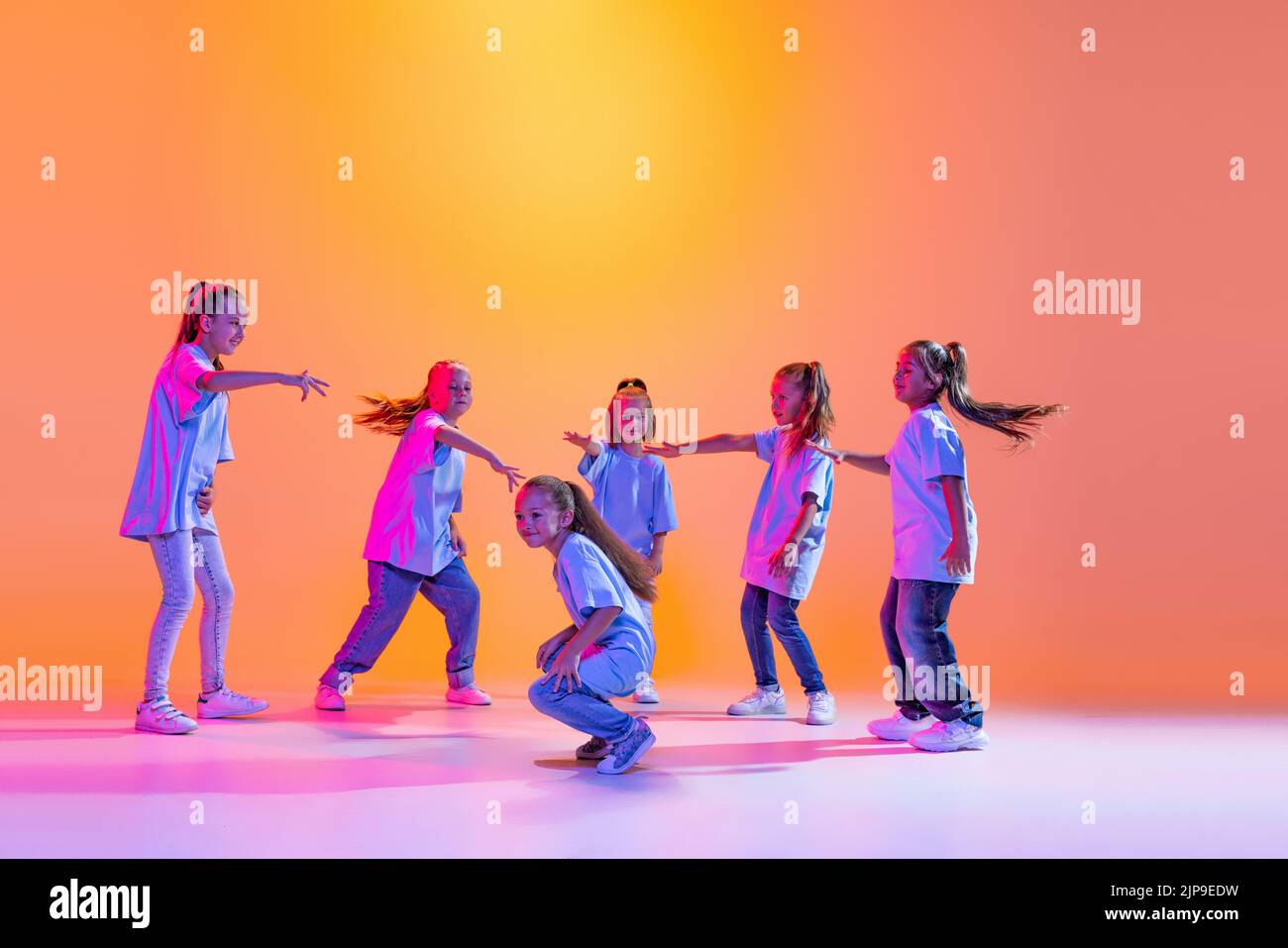 Portrait of cheerful, active little girls, happy kids dancing isolated ...