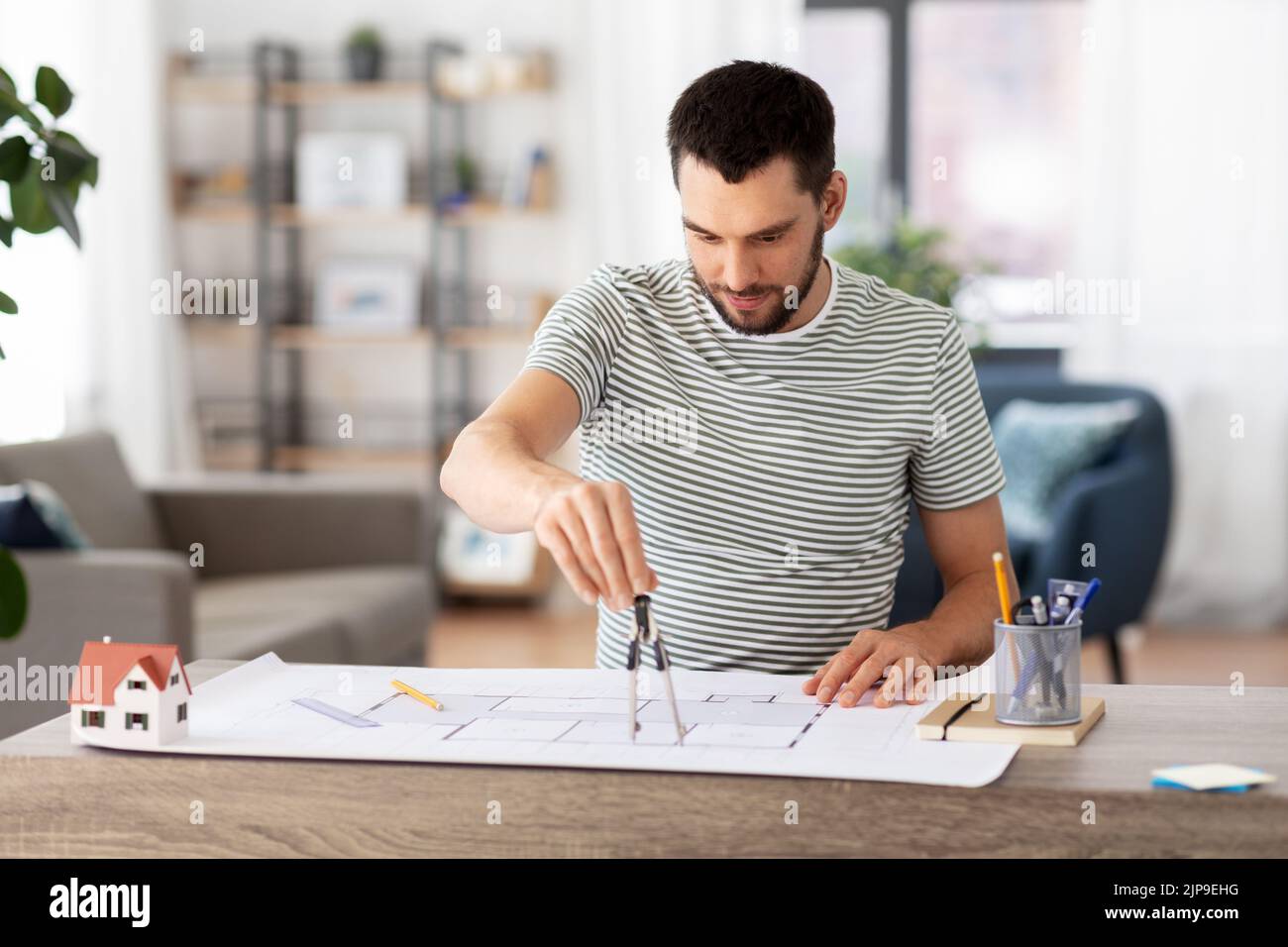 architect with blueprint working at home office Stock Photo - Alamy