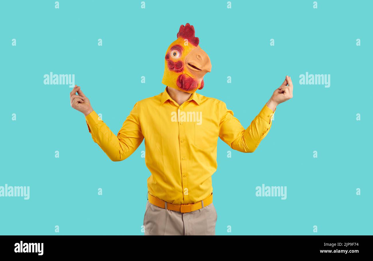 Funny man in mask of chicken pretending to be practicing yoga ...