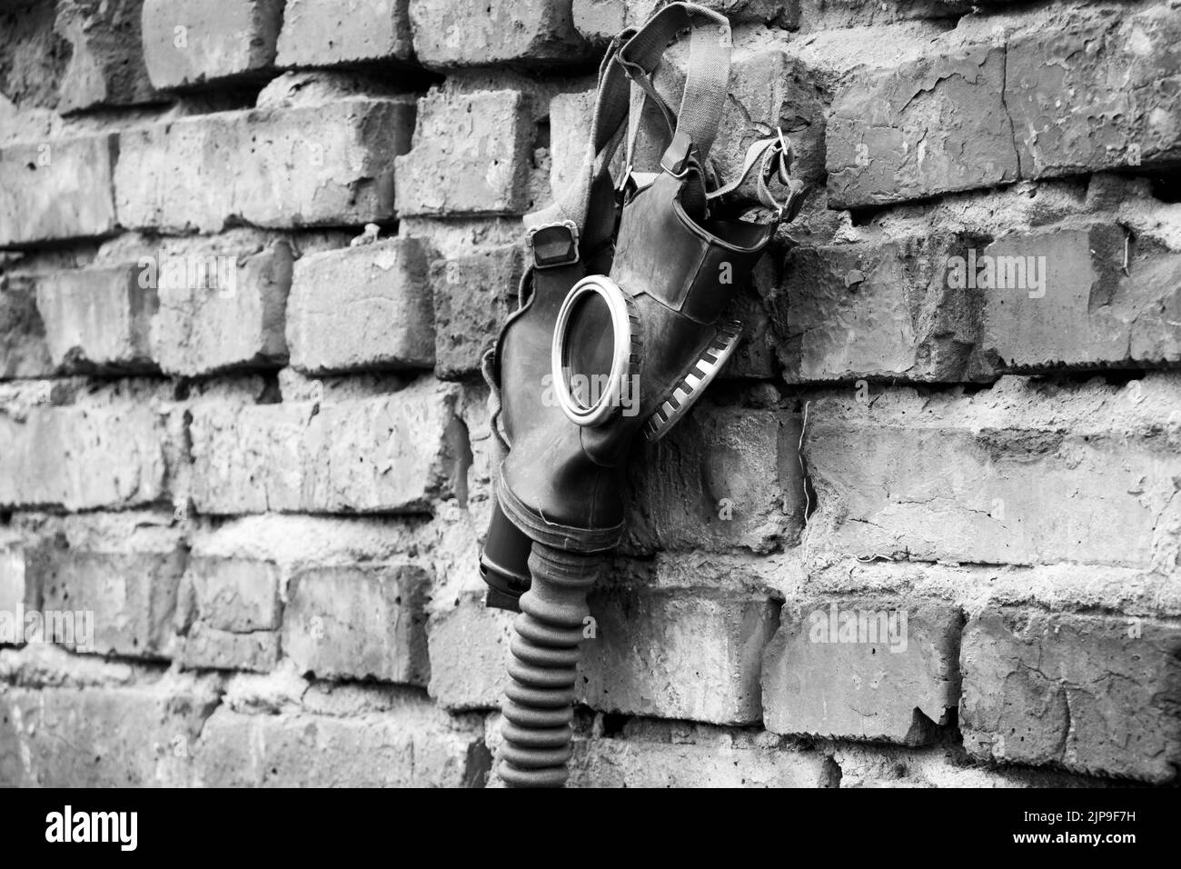 Vintage gas mask hangs on a brick wall, gas attack in Ukraine at war ...