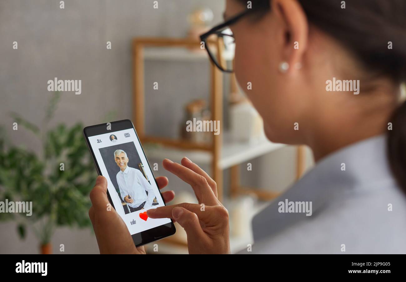 Woman who is looking for love scrolls through profiles of men in dating ...