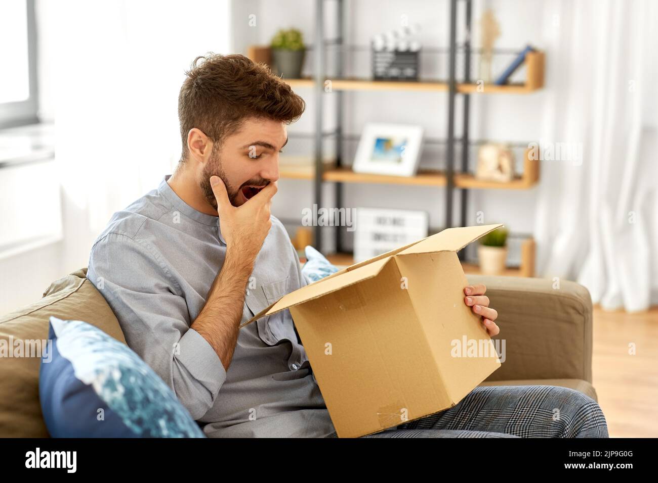 happy surprised man opening parcel box at home Stock Photo - Alamy