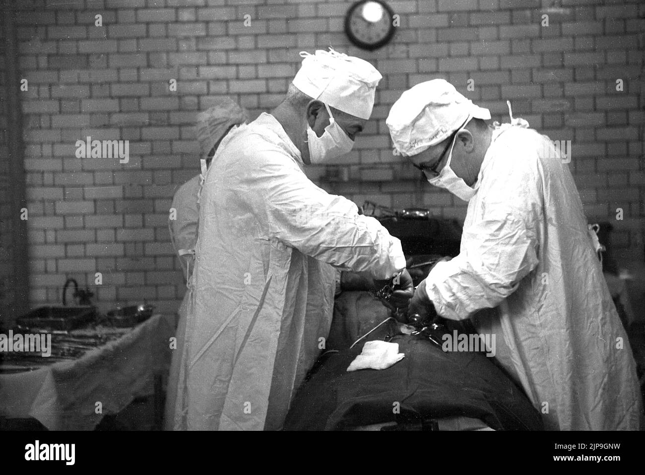 1953, historical, inside an operating theatre, two surgeons at work ...