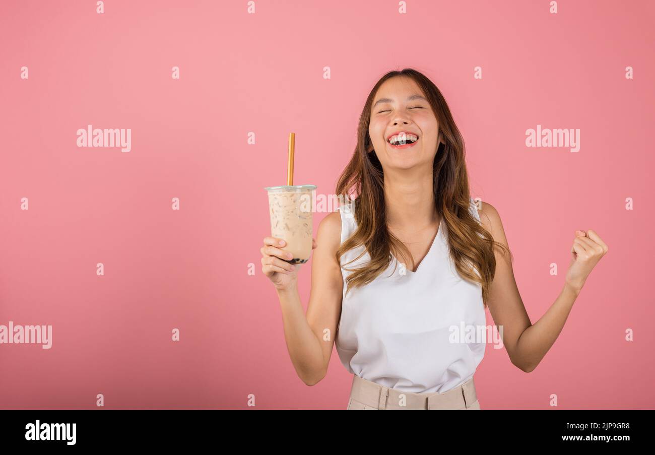 Excited Asian beautiful woman holding drinking brown sugar flavored ...