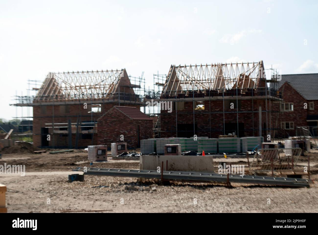 Partially constructed house surrounded by scaffolding on building site ...