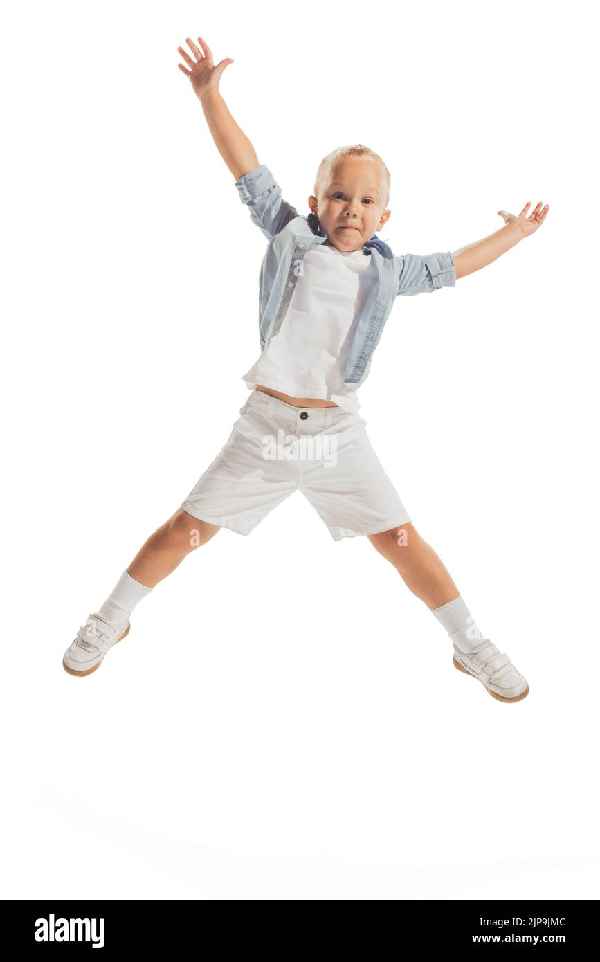 Portrait of little boy, child in casual outfit posing in a jump, having ...