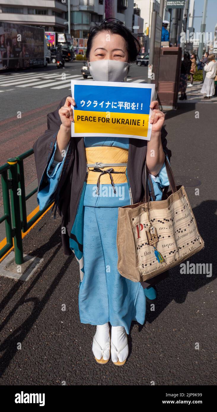 A beautiful Japanese woman in a blue and yellow Kimono in the colours ...