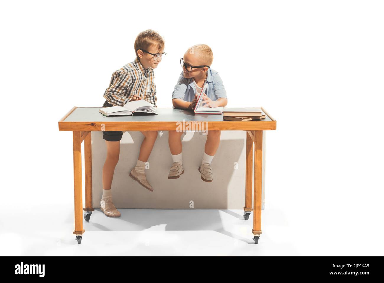 Portrait of two little boys, children, school pupils sitting at desk ...