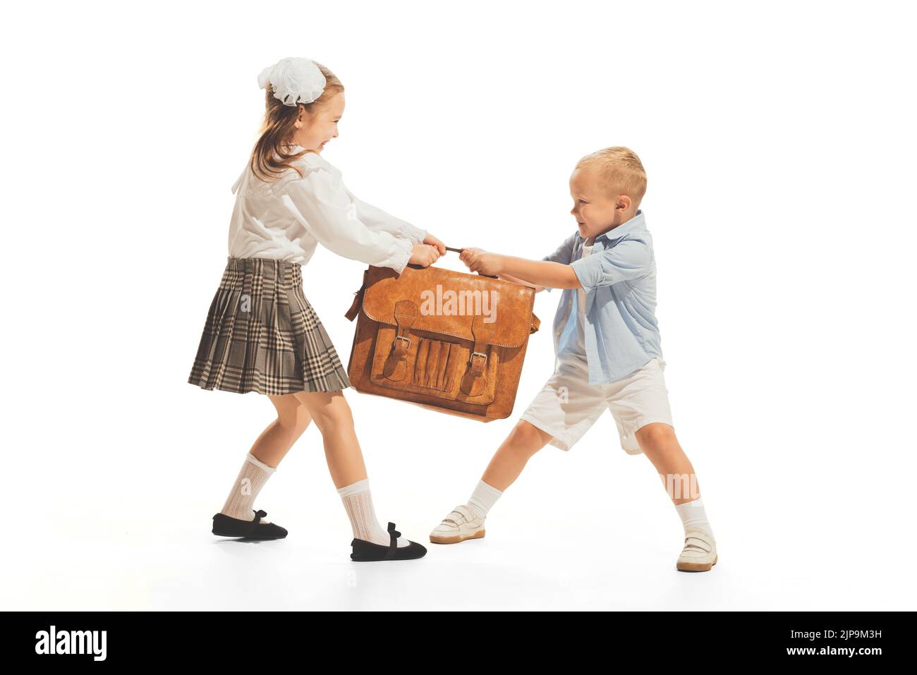 Portrait of children, little boy and girl pulling big vintage briefcase ...
