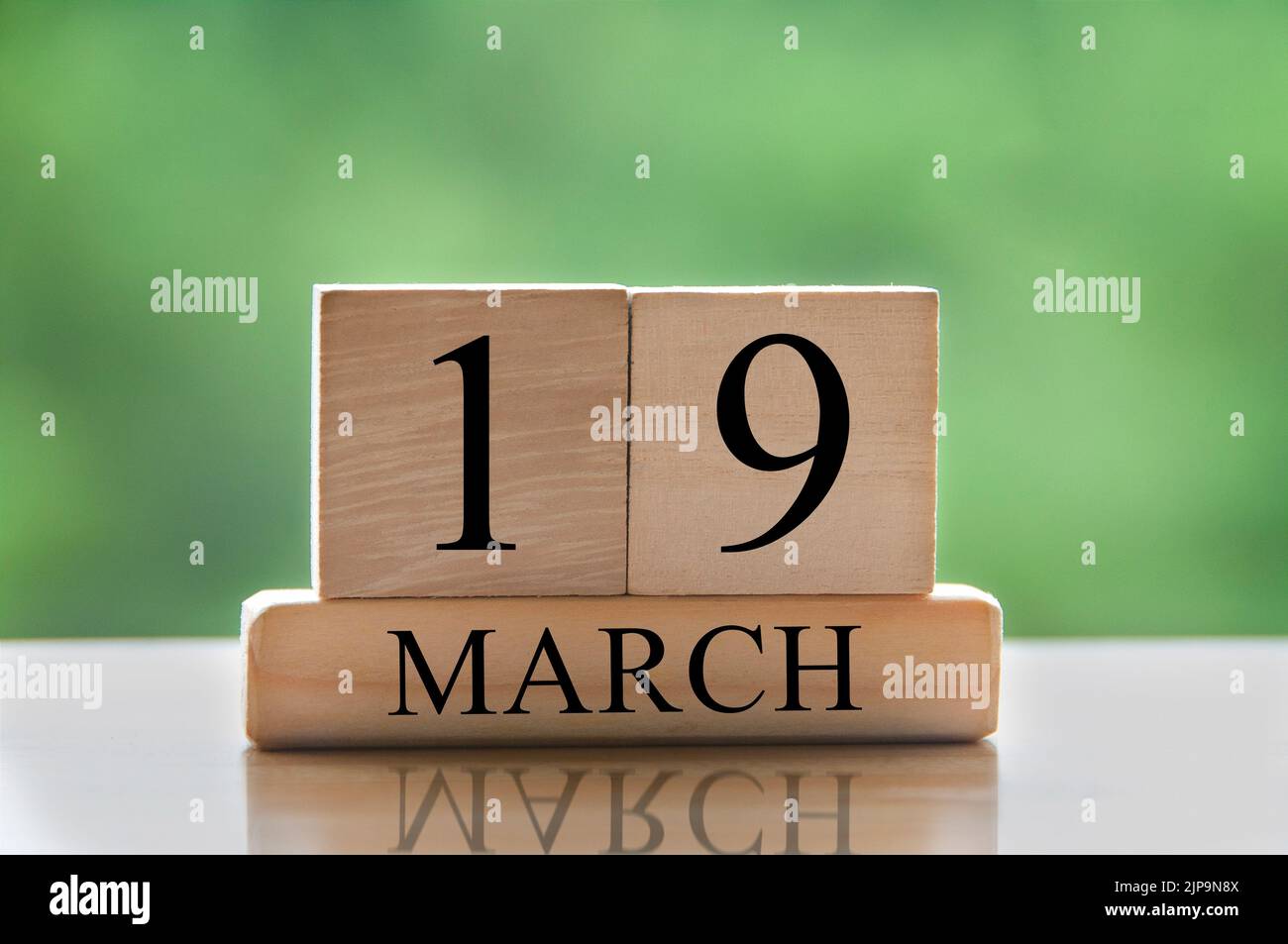 March 19 calendar date text on wooden blocks with blurred park ...