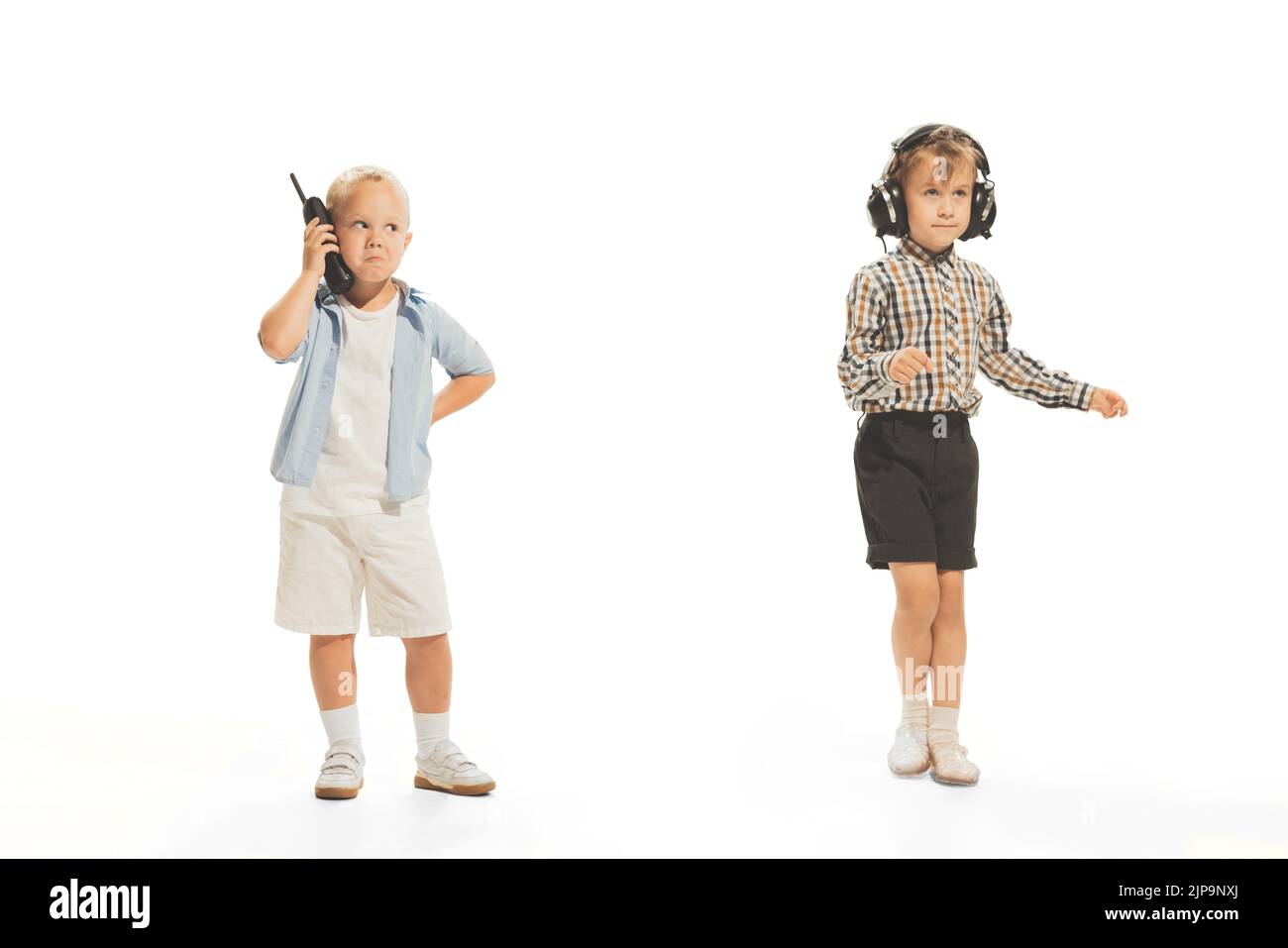 Portrait of little boys, children playing together, talking on phone ...
