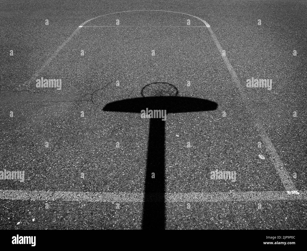 Shadow of basketball hoop and net on asphalt urban ghetto court with ...