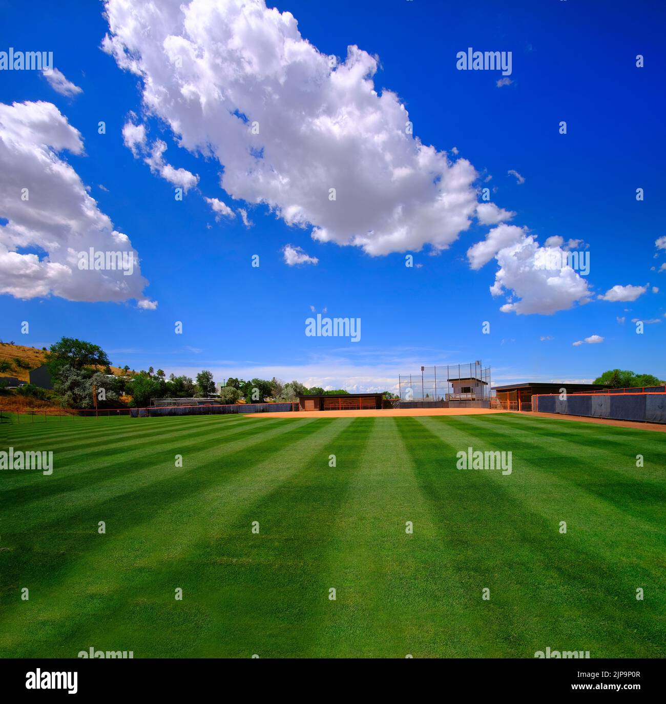 Manicured mowed grass lines on a baseball field diamond with blue sky ...