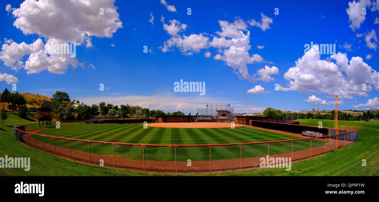 Manicured mowed grass lines on a baseball field diamond with blue sky ...