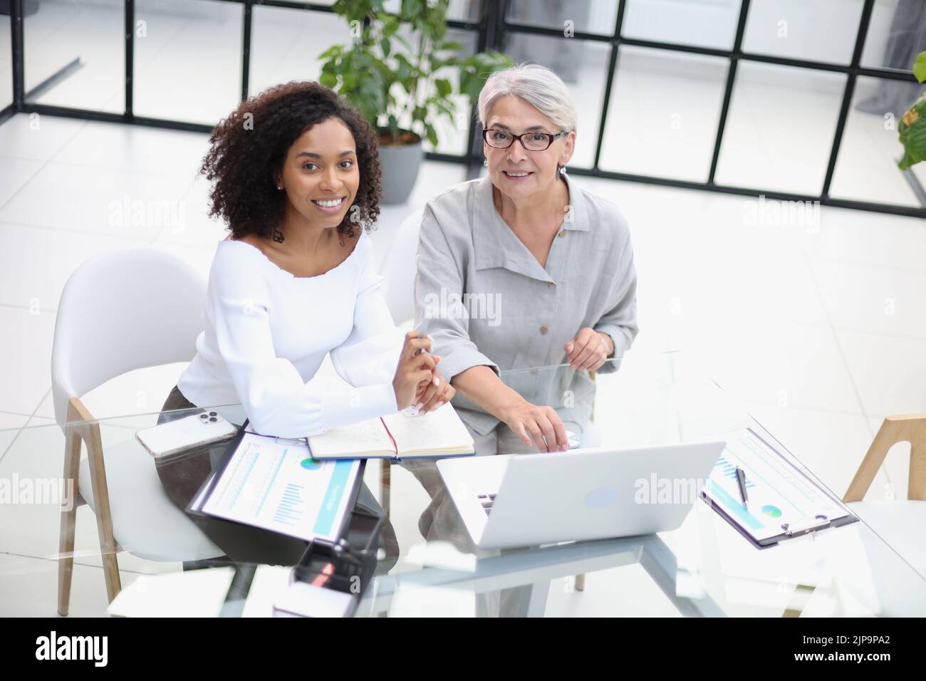 Female colleagues met in the office hall discussing work issues Stock ...