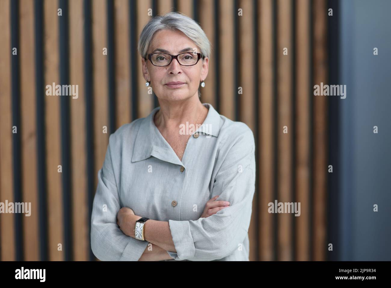 beautiful mature woman in office arms crossed Stock Photo - Alamy