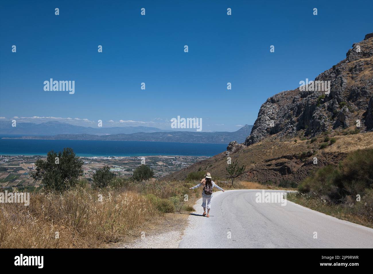 woman tourist walking down hill towards Corinth from the historical ...
