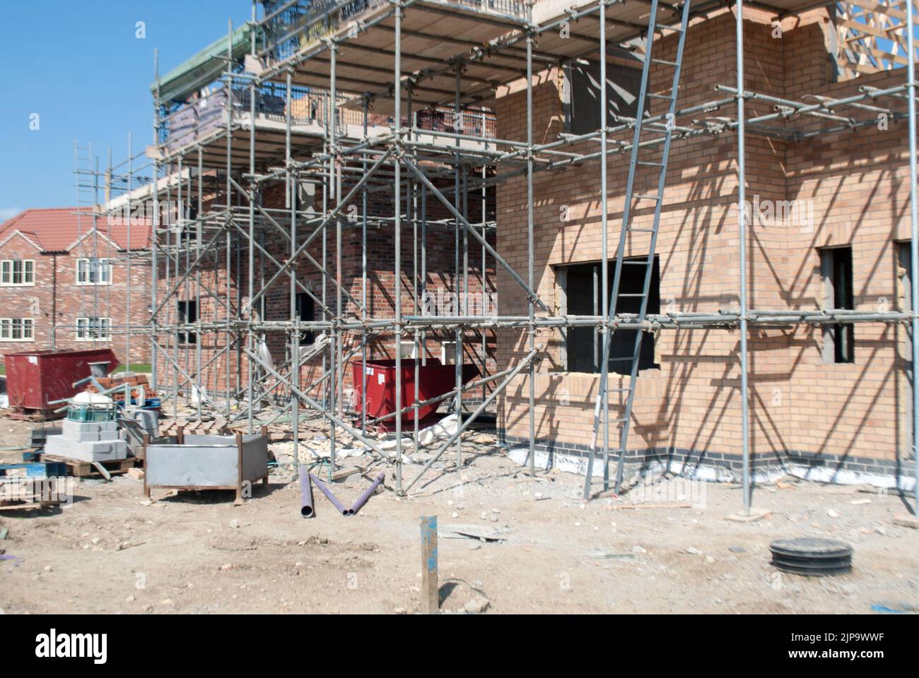 Partially constructed house surrounded by scaffolding on building site ...