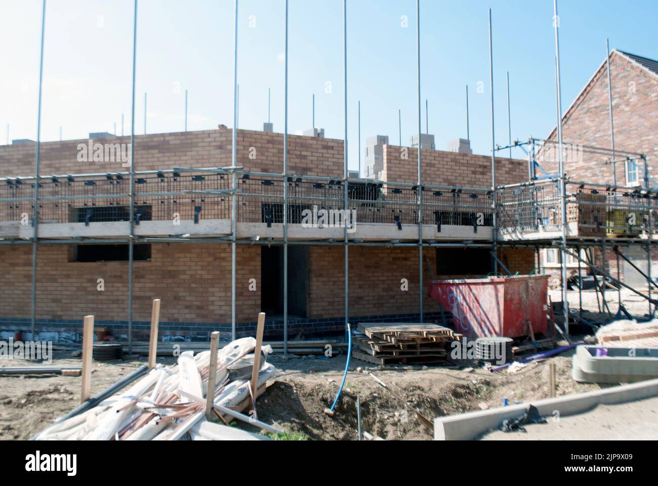 Partially constructed house surrounded by scaffolding on building site ...