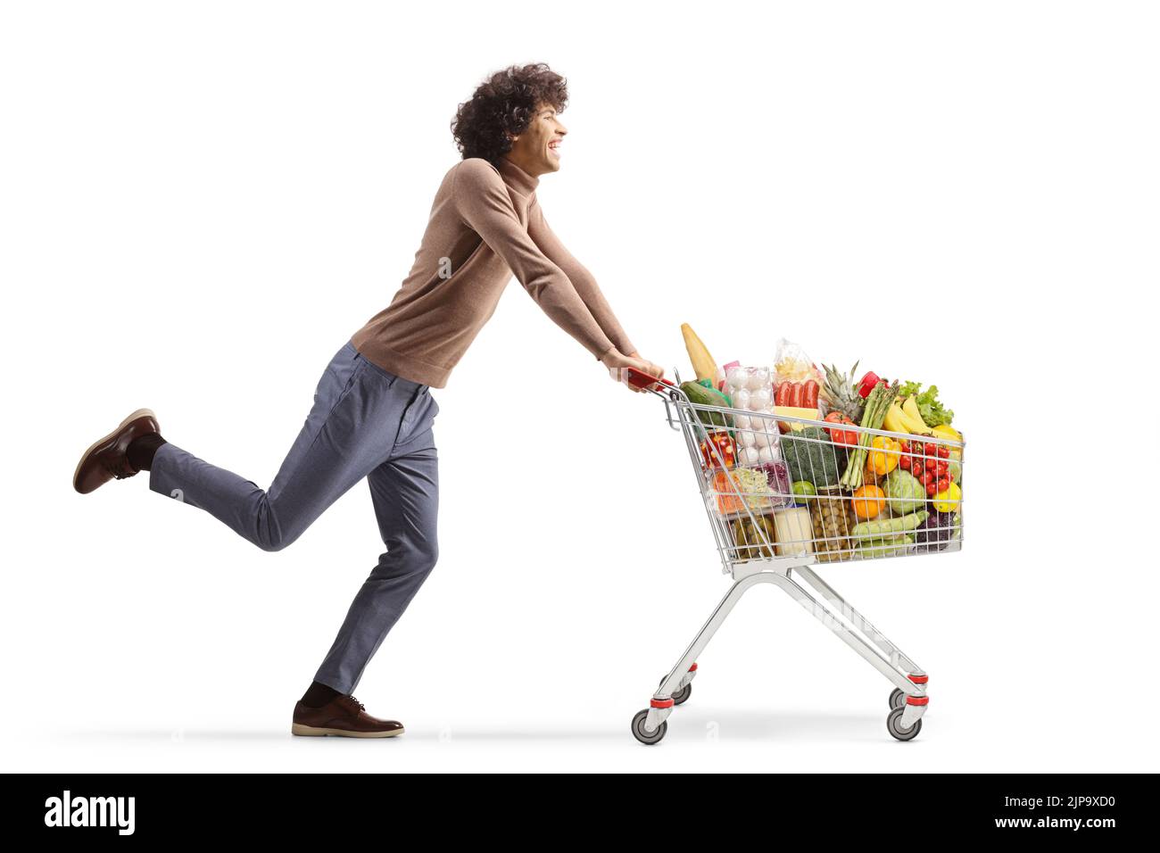 Full length profile shot of a young man running with a shopping cart ...