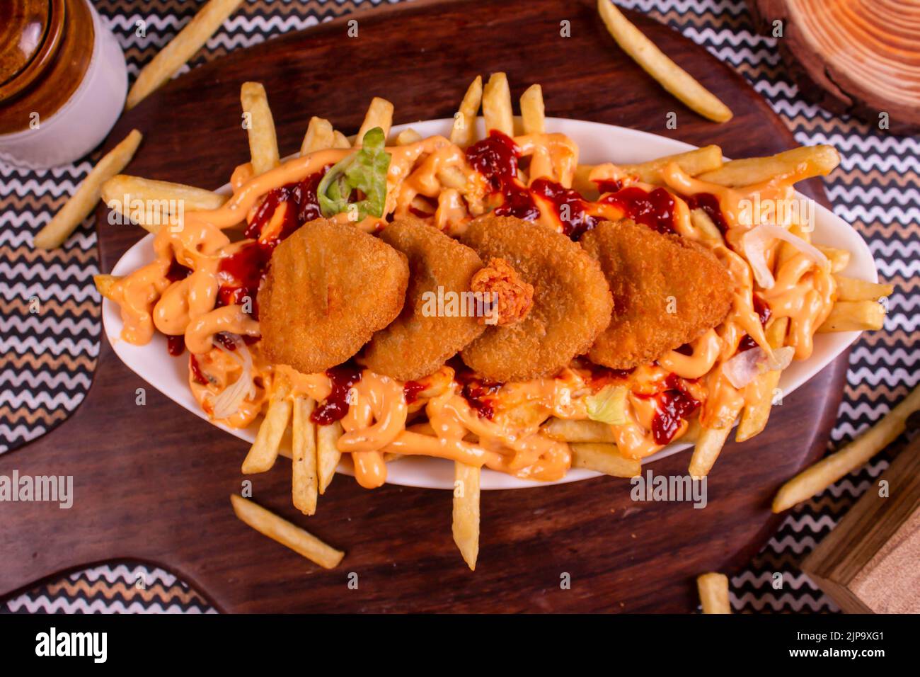 Dish of CHEESY NUGGET FRIES at cafe restaurant. American fast food dish ...