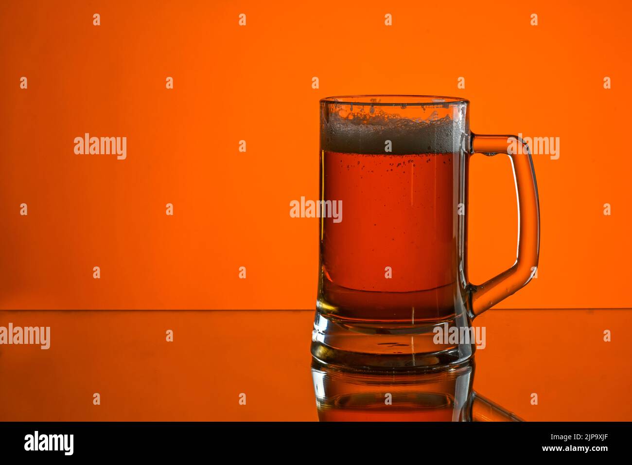 Ice cold beer glass on red background Stock Photo - Alamy