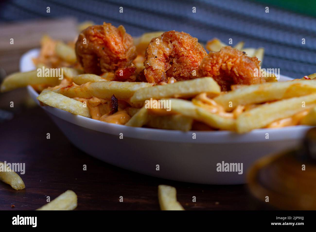 Dish of CHEESY PRAWN FRIES at cafe restaurant. American fast food dish ...