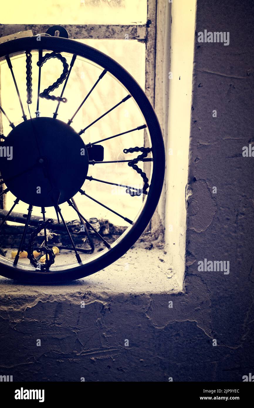 A clock made out of a bicycle wheel and bits of bike chain for numbers ...