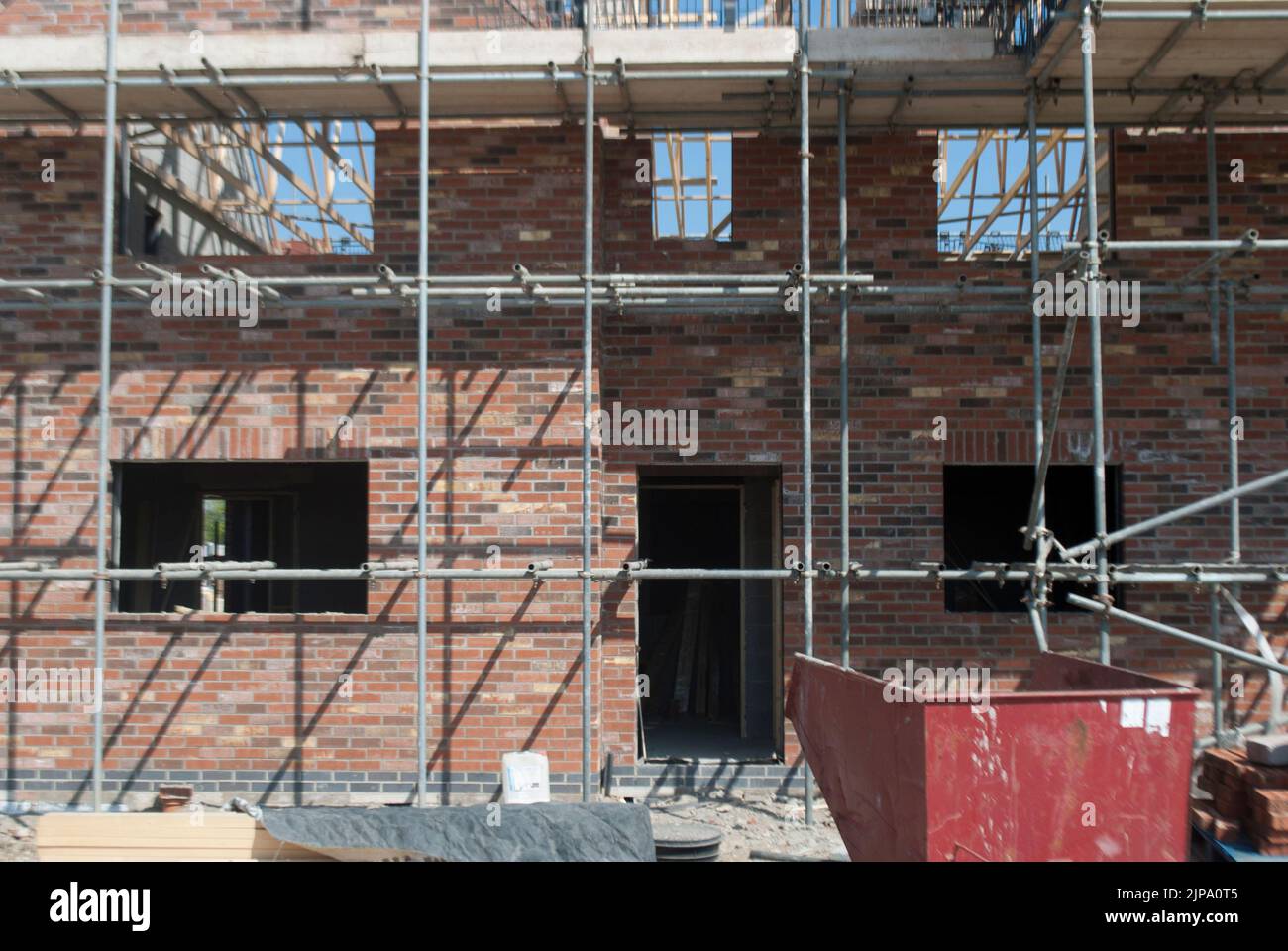 Partially constructed house surrounded by scaffolding on building site ...