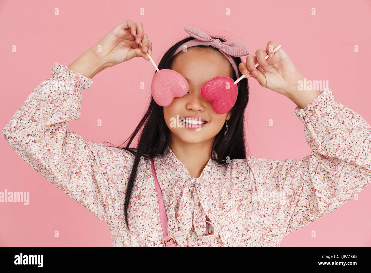 Asian girl wearing dress making fun with with heart lollipop isolated ...