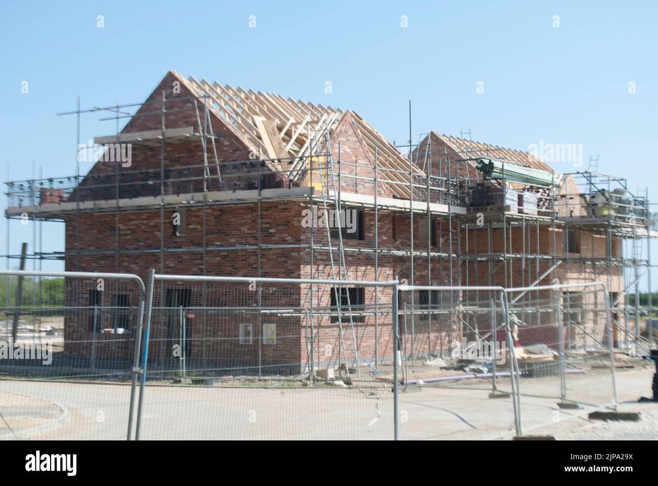 Partially constructed house surrounded by scaffolding on building site ...