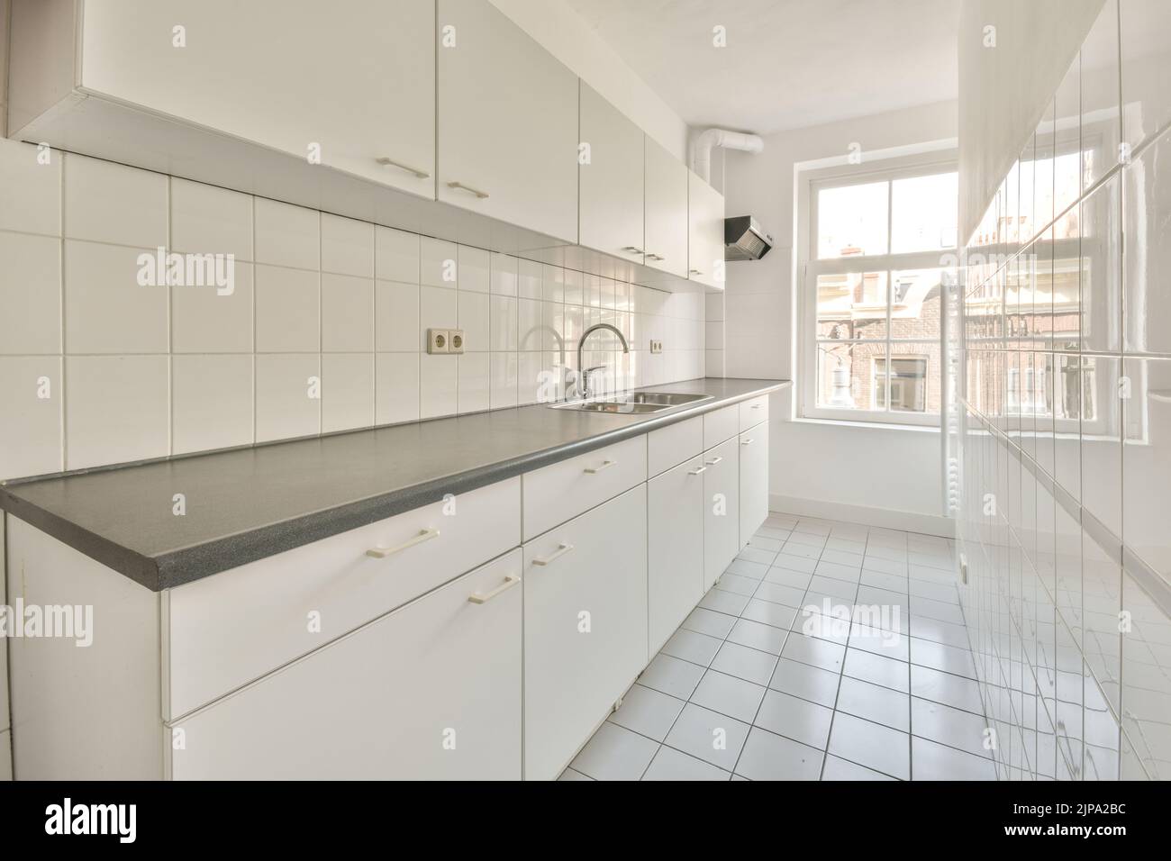 Interior of empty white kitchen with corridor and wooden parquet floor ...