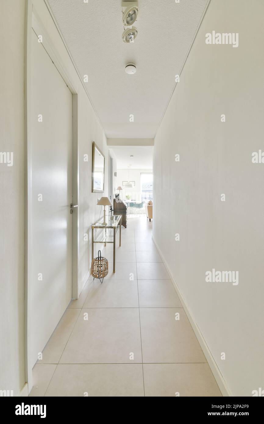 Perspective view of empty narrow hallway with white walls and wardrobe ...