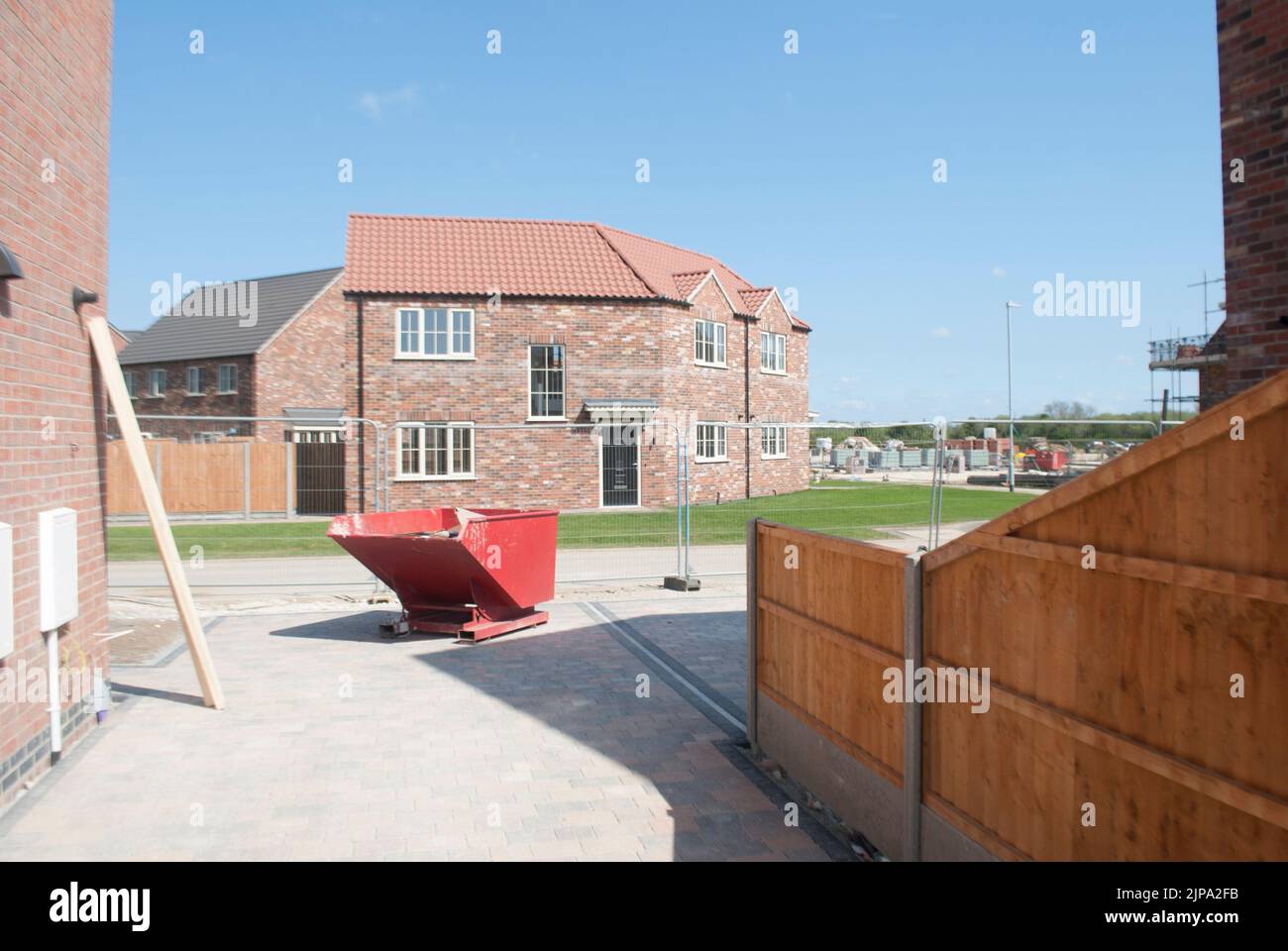 Newly constructed houses on building site with red skip Stock Photo - Alamy