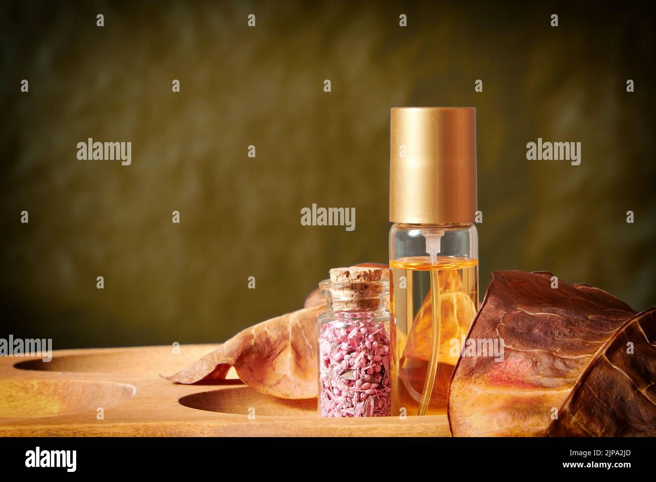 Small perfume vial with natural essence and pink flower petals and ...