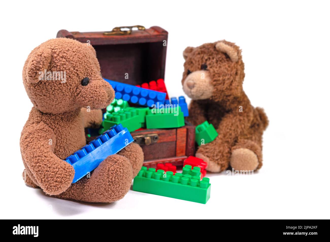 Plush bears and plastic building blocks against a white background ...