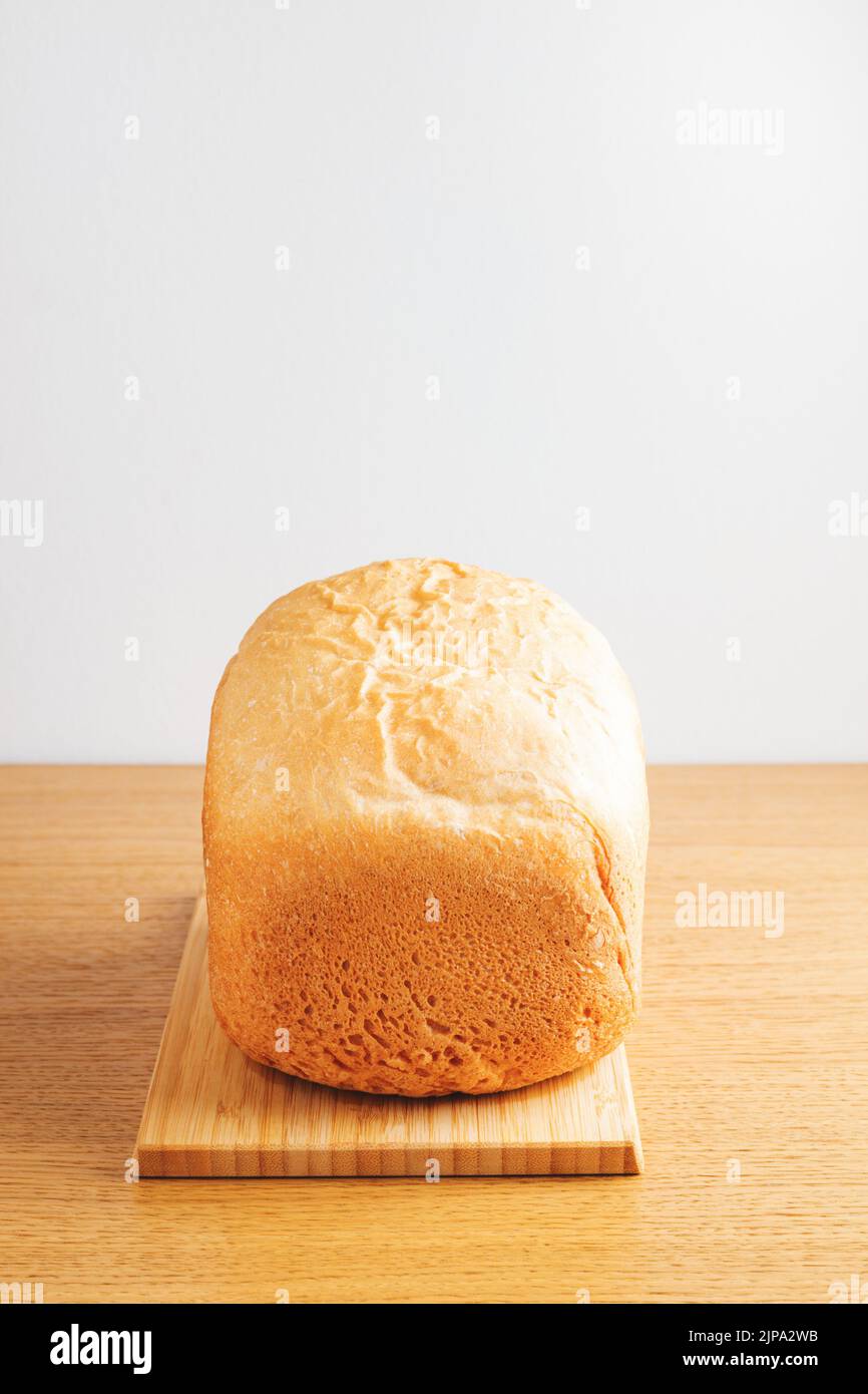 Homemade white wheat bread on wooden cutting board and wooden table ...