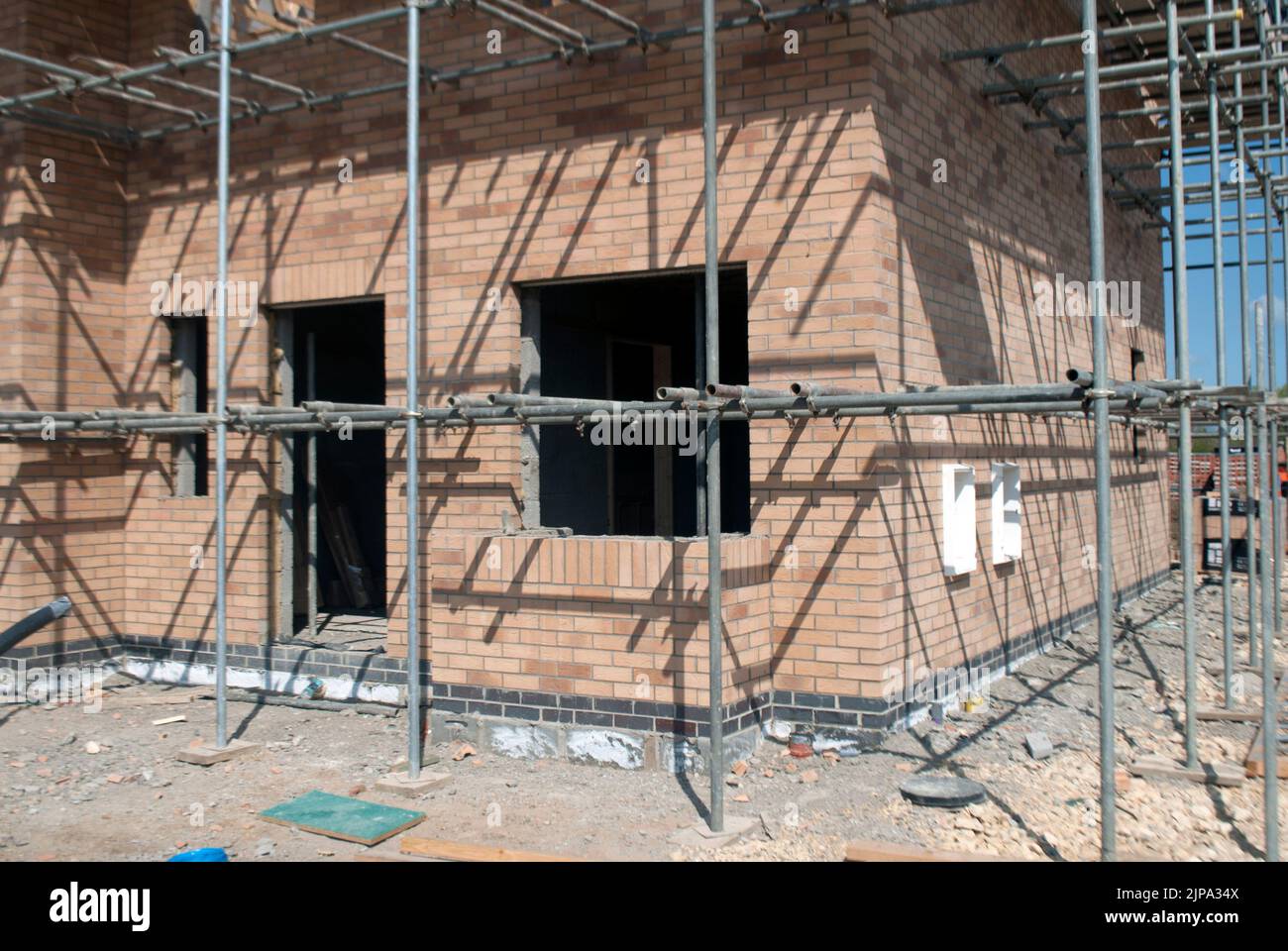 Partially constructed house surrounded by scaffolding on building site ...