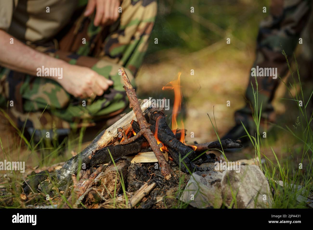 Man is making campfire in the woods. The concept of adventure, travel ...