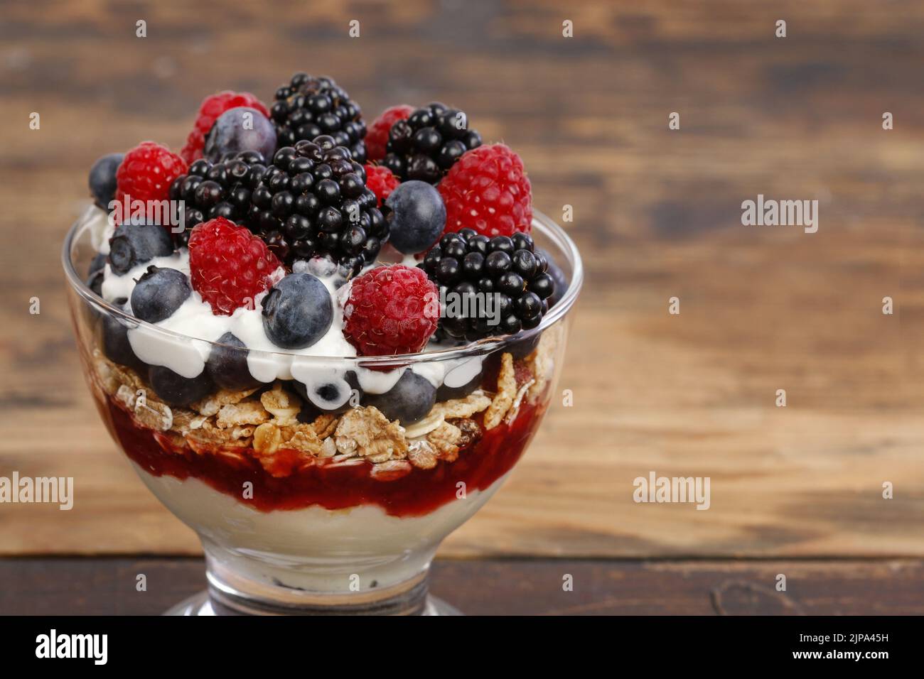 Portion of layer dessert with fresh fruits and muesli. Party dessert ...