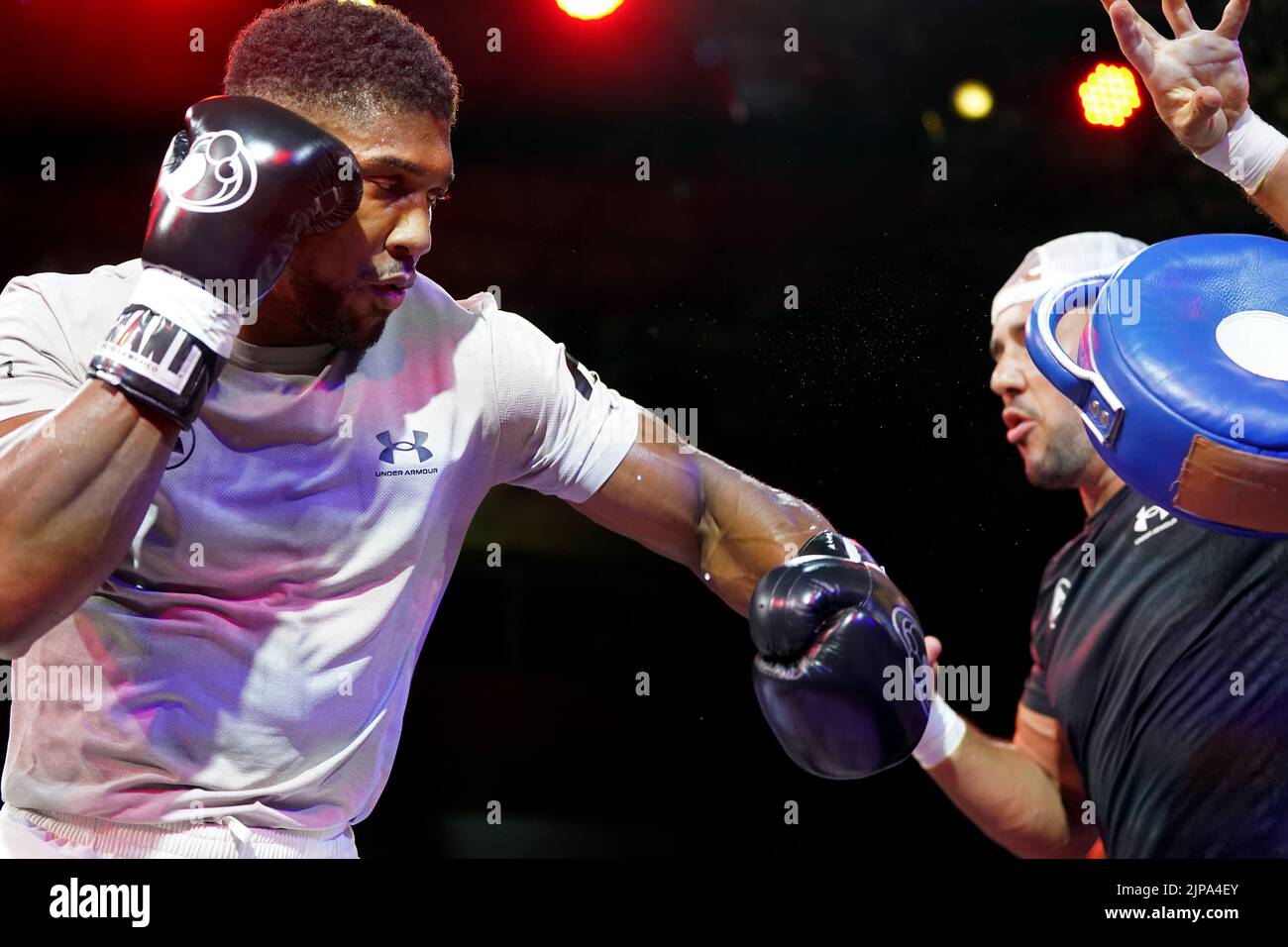 Anthony Joshua (left) hits a punch pad from a sparring partner's hand ...