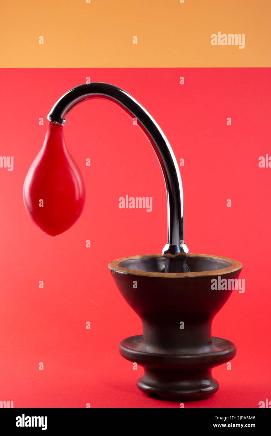 Vase with a balloon in a water tap on a colored background Stock Photo ...