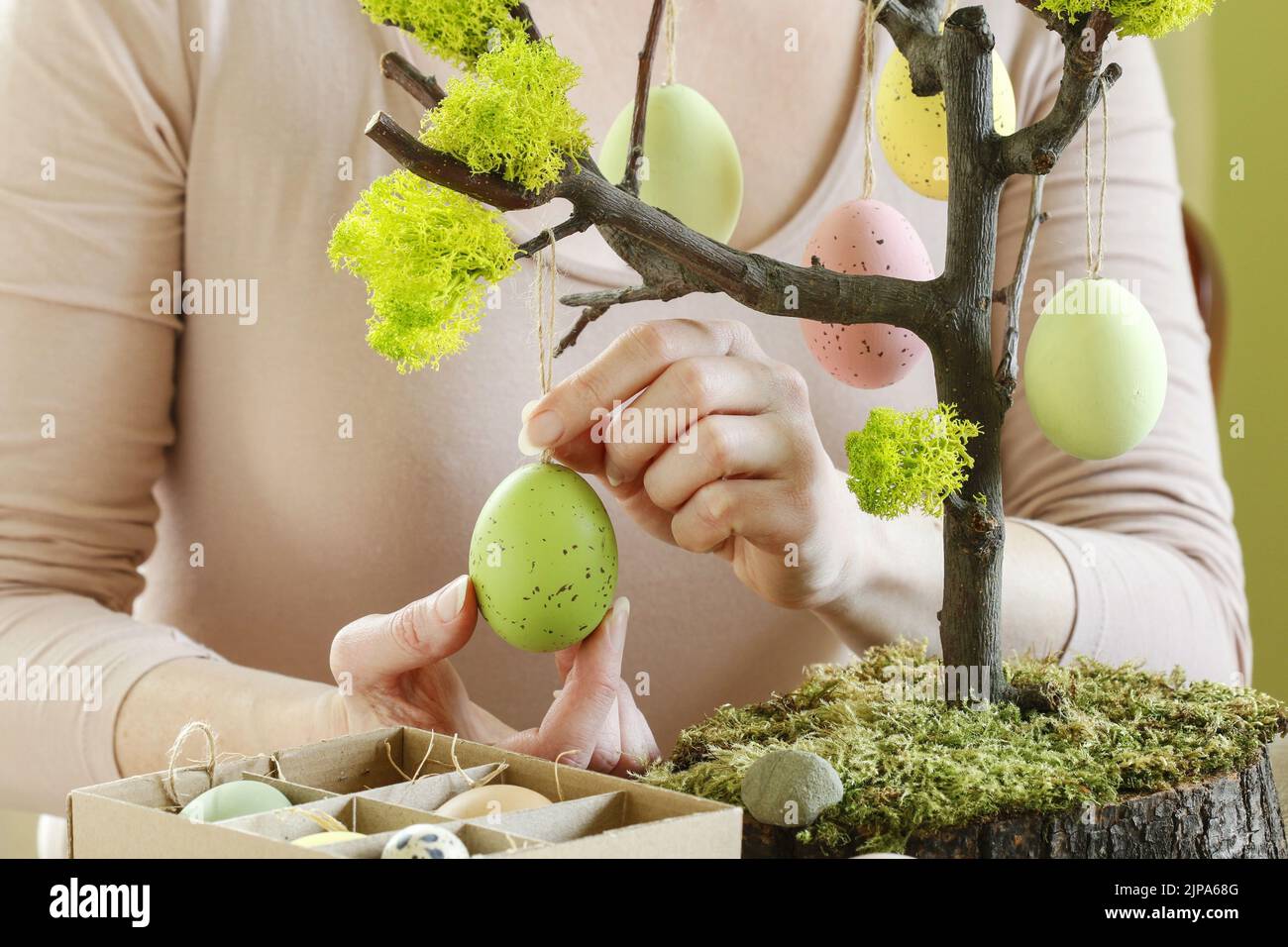 Florist at work: woman shows how to make Easter decoration in tree ...
