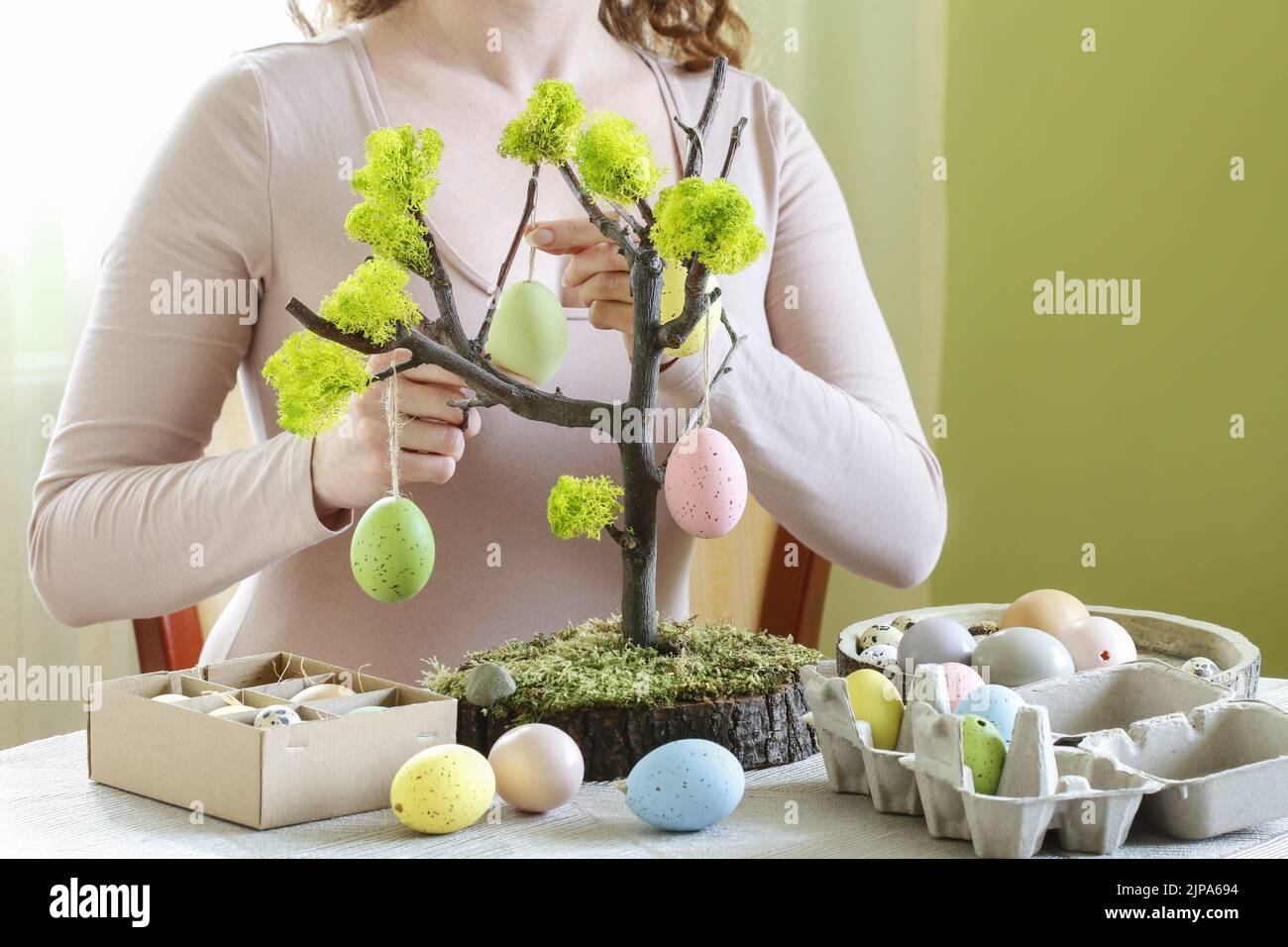 Florist at work: woman shows how to make Easter decoration in tree ...