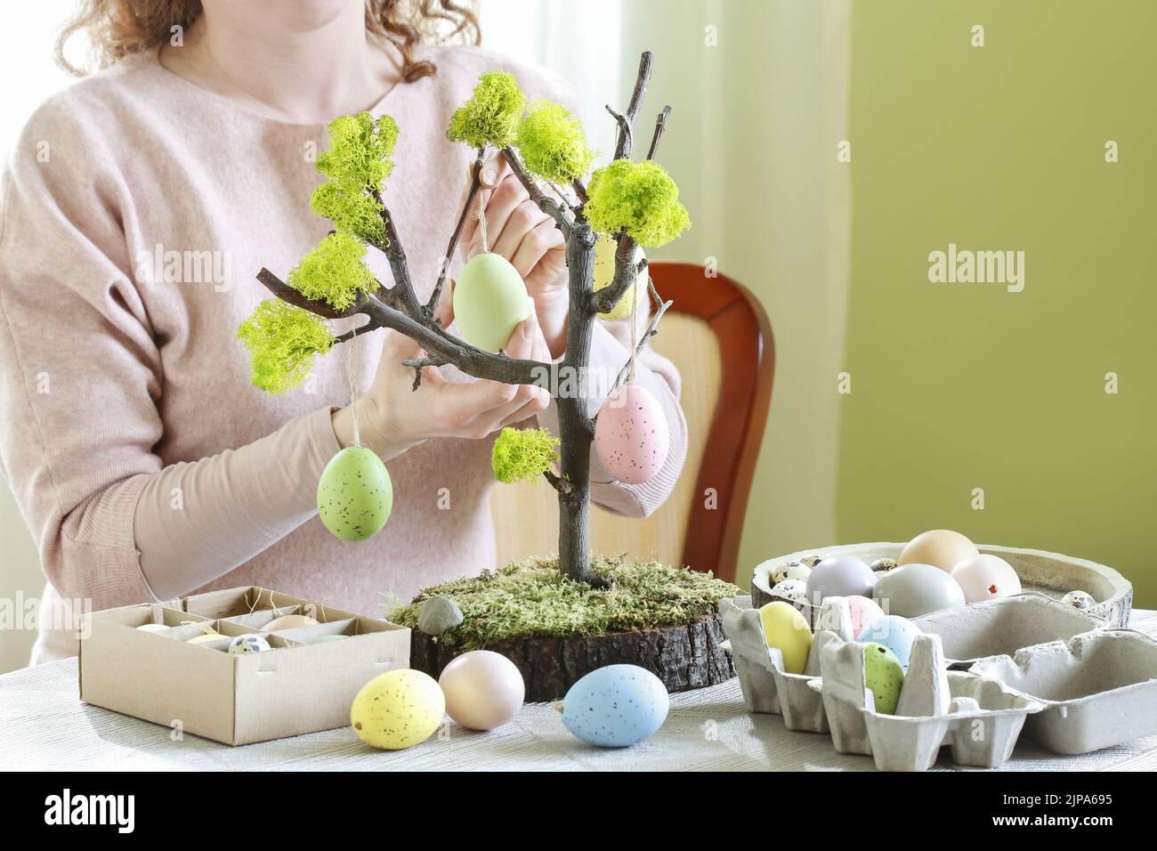 Florist at work: woman shows how to make Easter decoration in tree ...