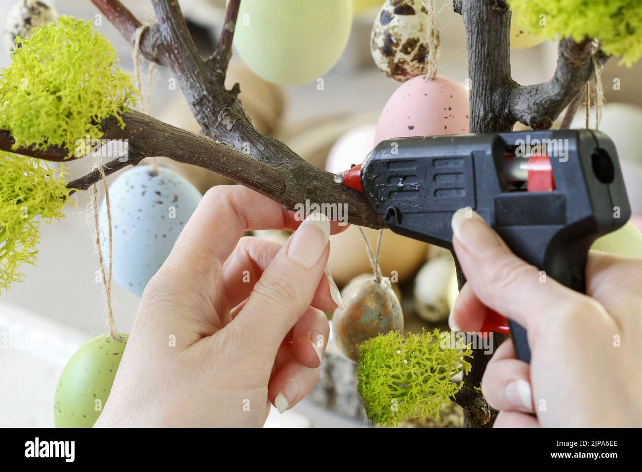 Florist at work: woman shows how to make Easter decoration in tree ...