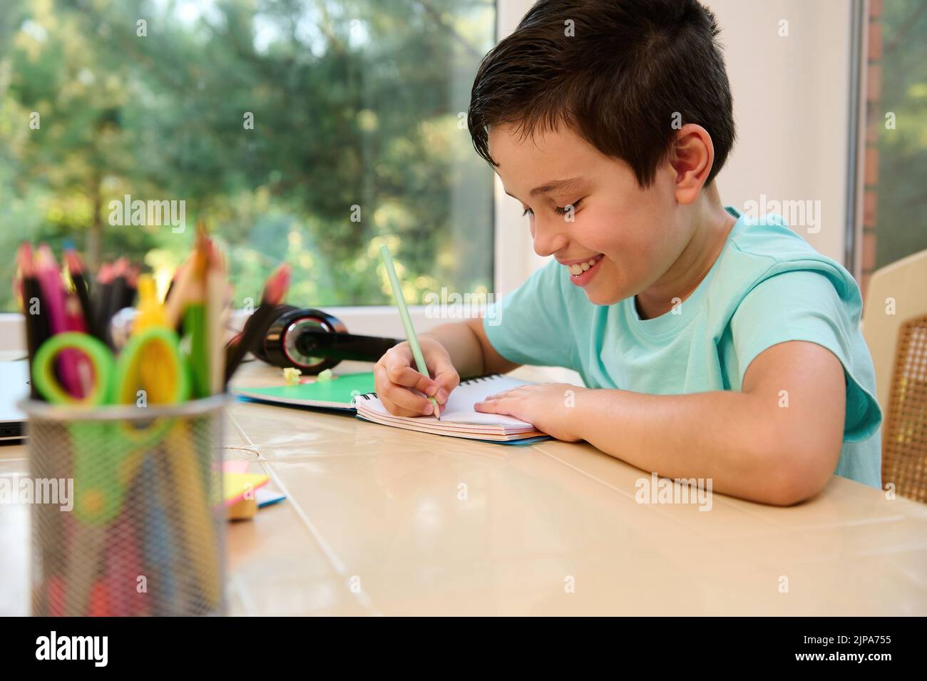 Cute child, schoolboy, doing homework, learning new educational subject ...